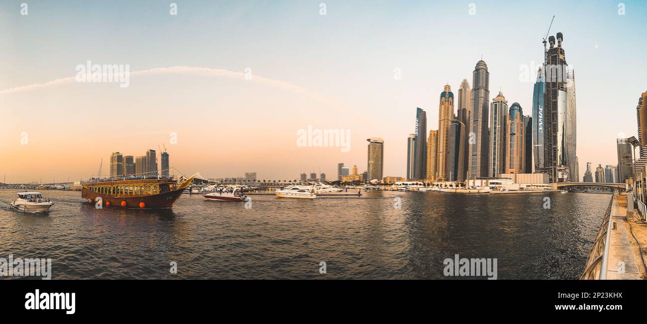 Dubai Marina, harbour, cruise boat and canal promenade view at sunset ...
