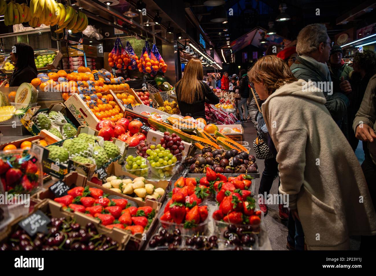 Barcelona,Spain-February 21,2023 Customers stand at a fruit h booth in ...