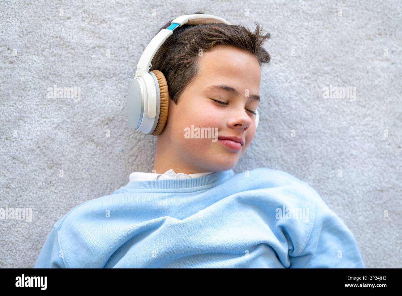 Child wearing headphones listens to music. Cute boy listening to music ...