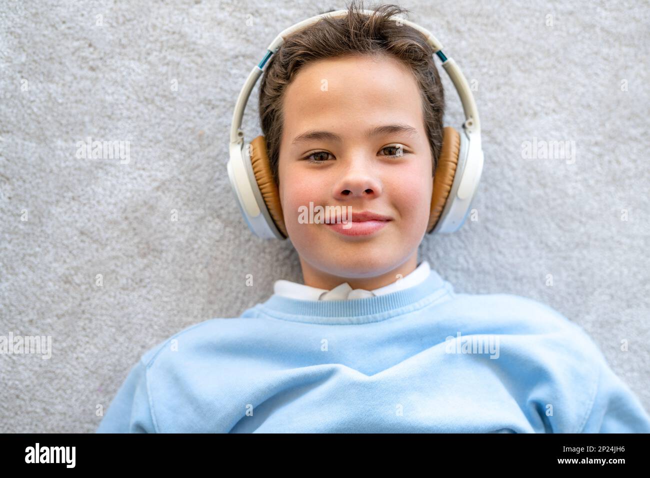 Child wearing headphones listens to music. Cute boy listening to music ...