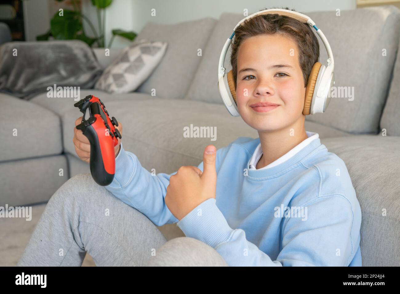 Shot of an adorable young boy wearing headphones while playing video ...