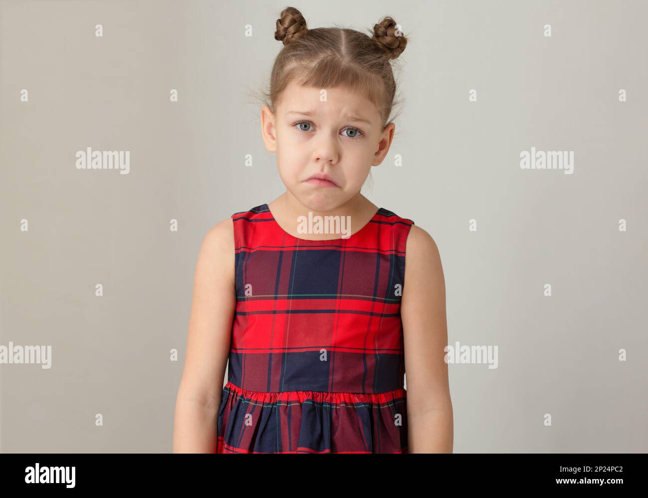 Sad and unhappy child because of distress, pain or sorrow on grey ...