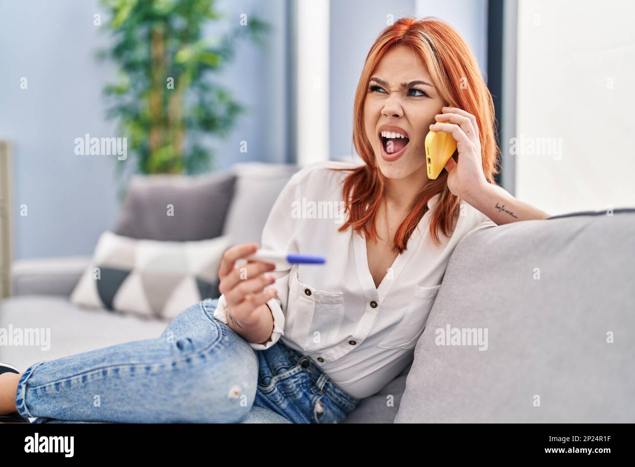 Young caucasian woman holding pregnancy test result speaking on the ...