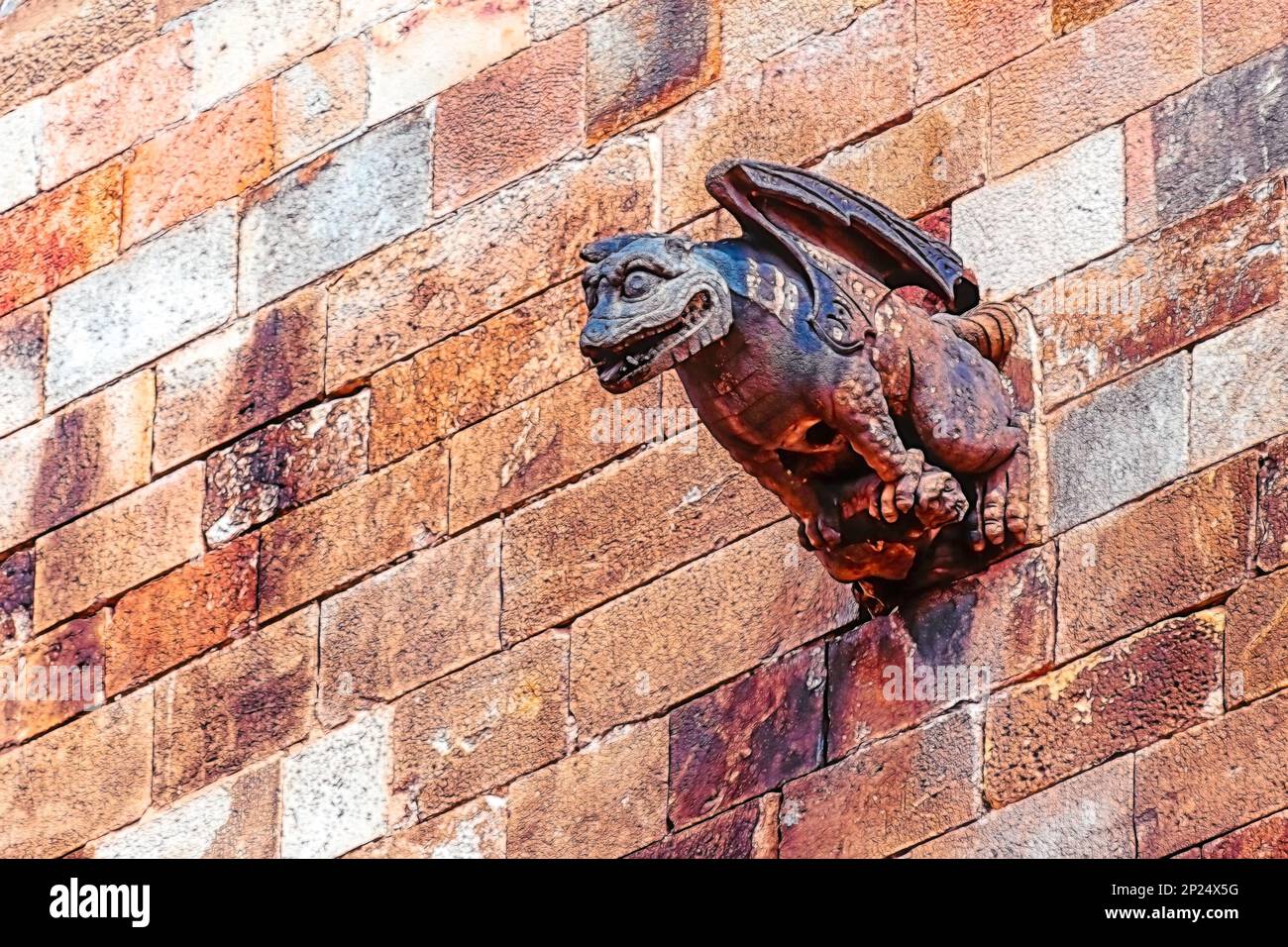 Antique stone gargoyle decorating a medieval stone wall, Barcelona ...