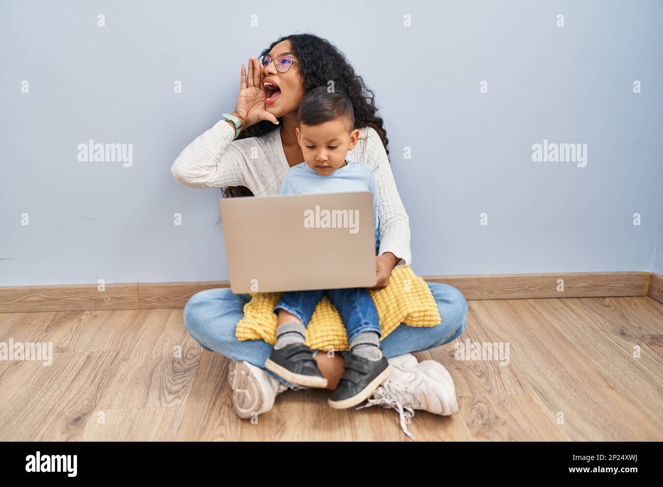 Young hispanic mother and kid using computer laptop sitting on the ...