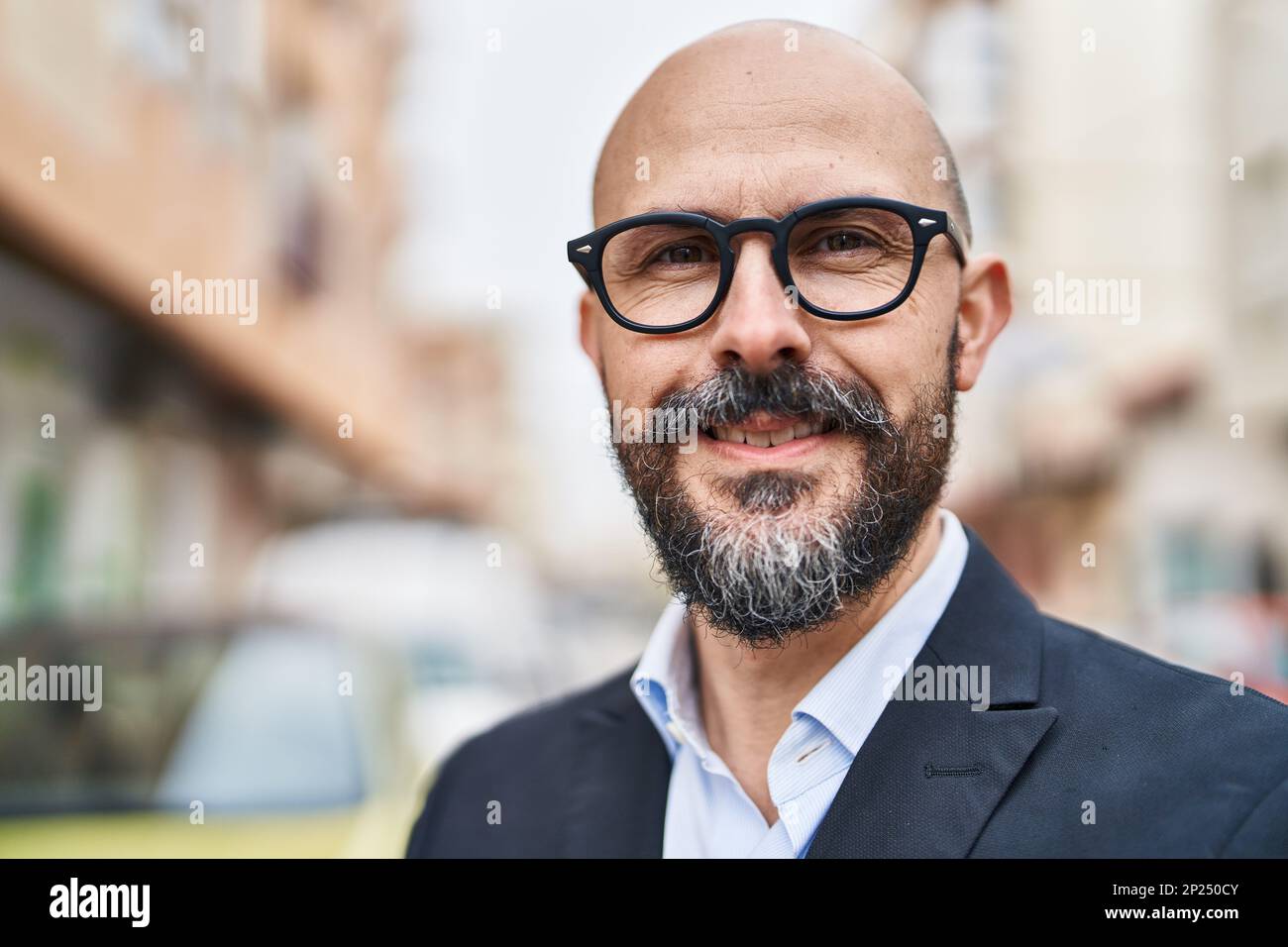Young bald man business worker smiling confident standng at street ...