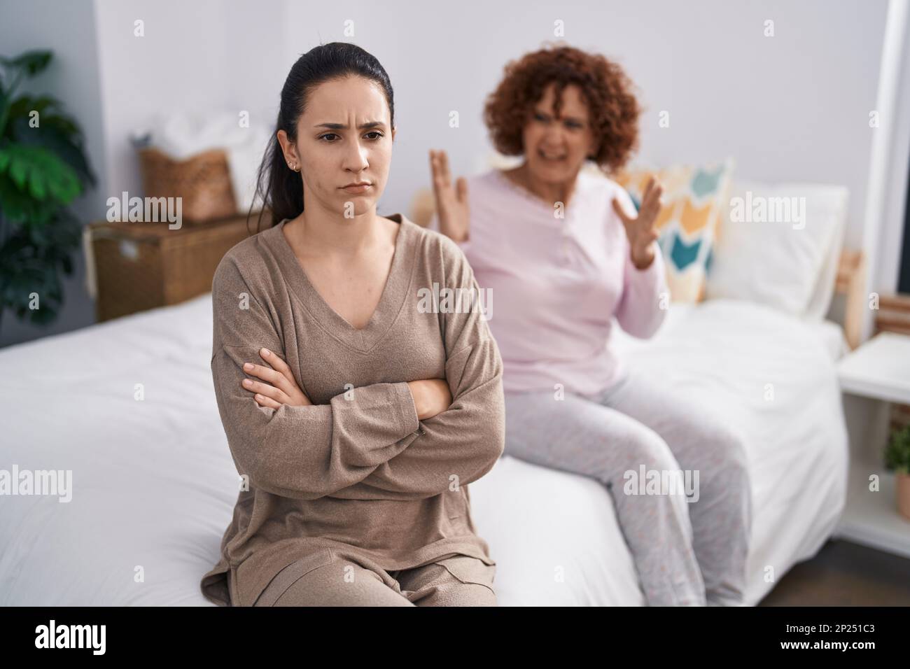 Two women mother and daughter arguing sitting on bed Stock Photo - Alamy