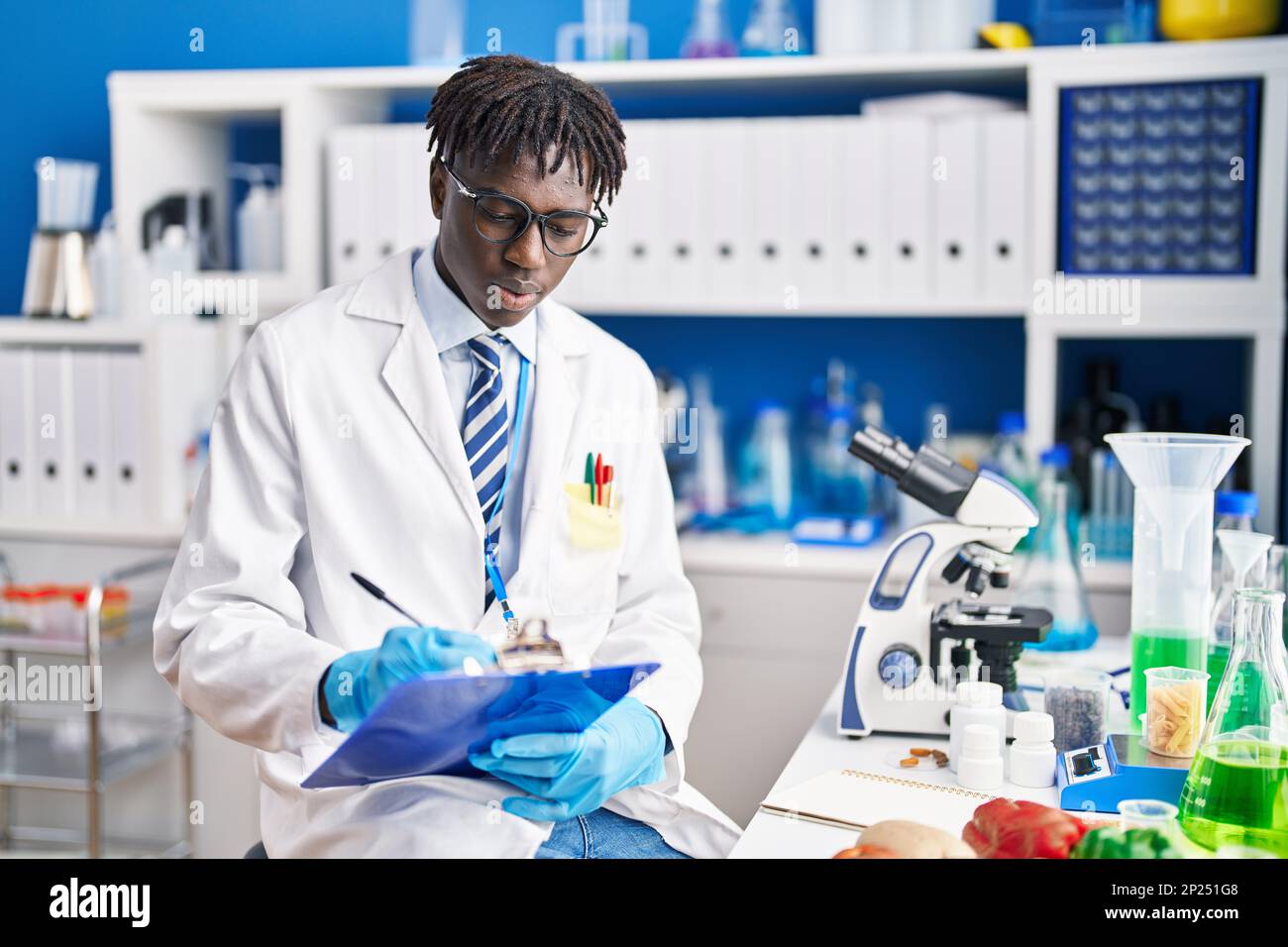 African american man scientist writing report at laboratory Stock Photo ...