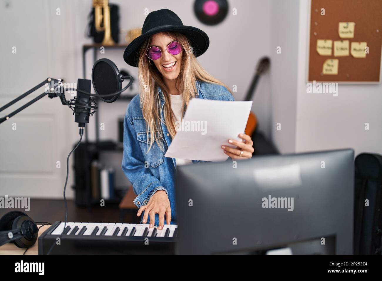 Young woman musician singing song playing piano keyboard at music ...