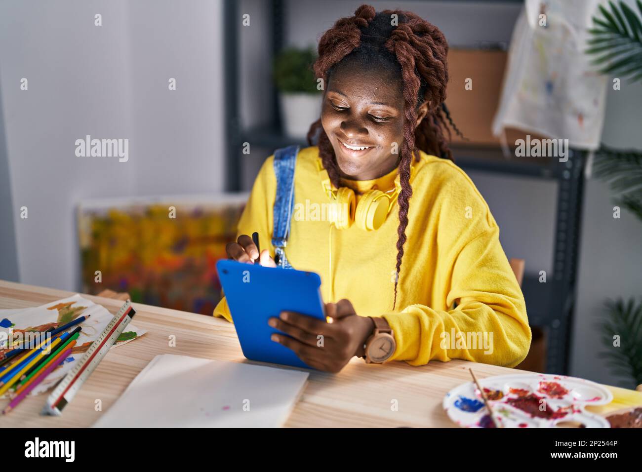 African american woman artist smiling confident drawing on touchpad at ...