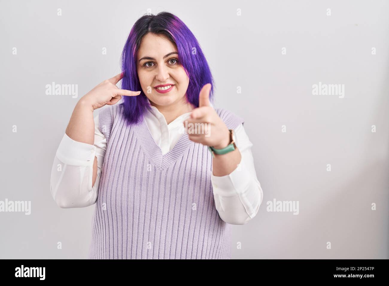 Plus size woman wit purple hair standing over white background smiling ...