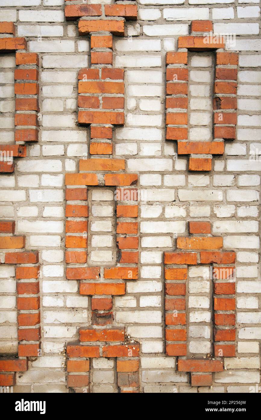 Decorative brickwork in a brick house wall. Orange geometric pattern on ...