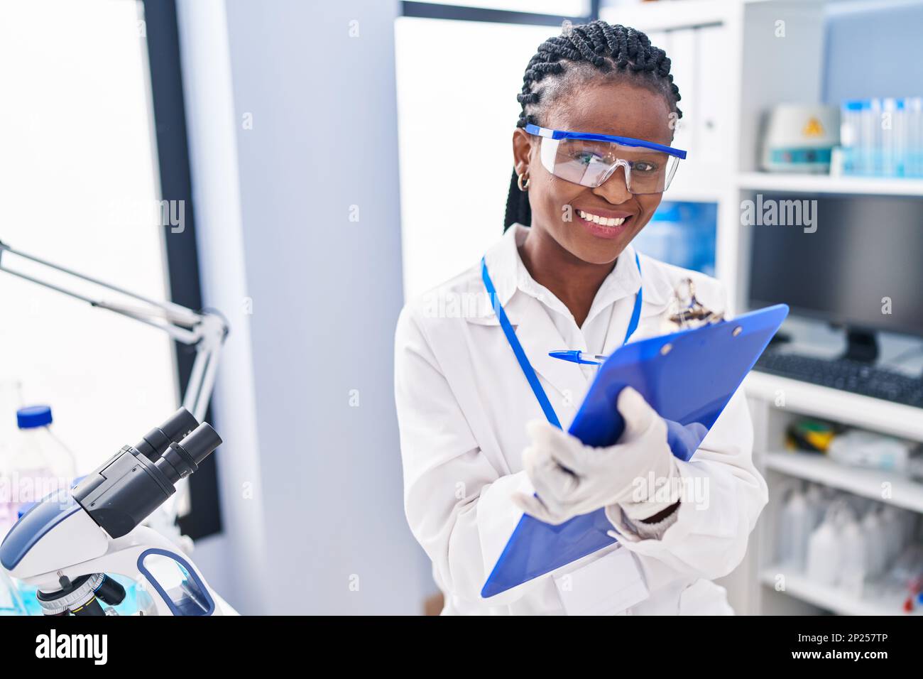 African american woman scientist writing report working at laboratory Stock Photo - Alamy