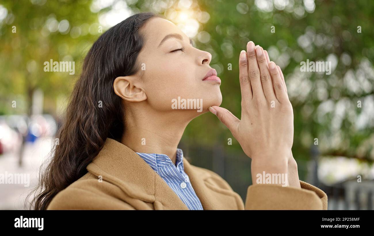 Young beautiful hispanic woman praying with closed eyes at park Stock ...