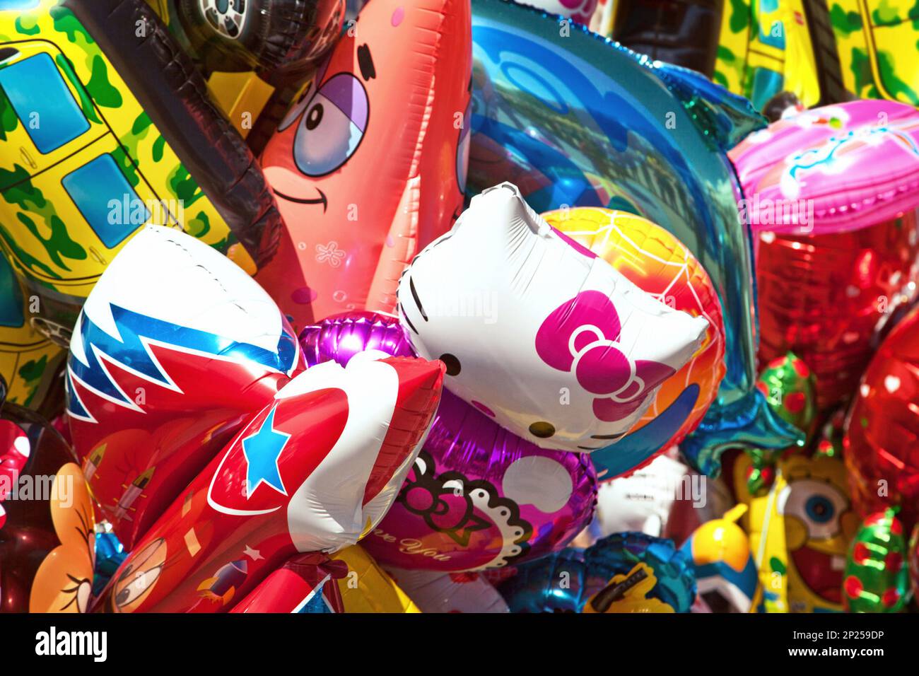 Bunch of various cartoon characters balloons at fair. Hello Kitty ...