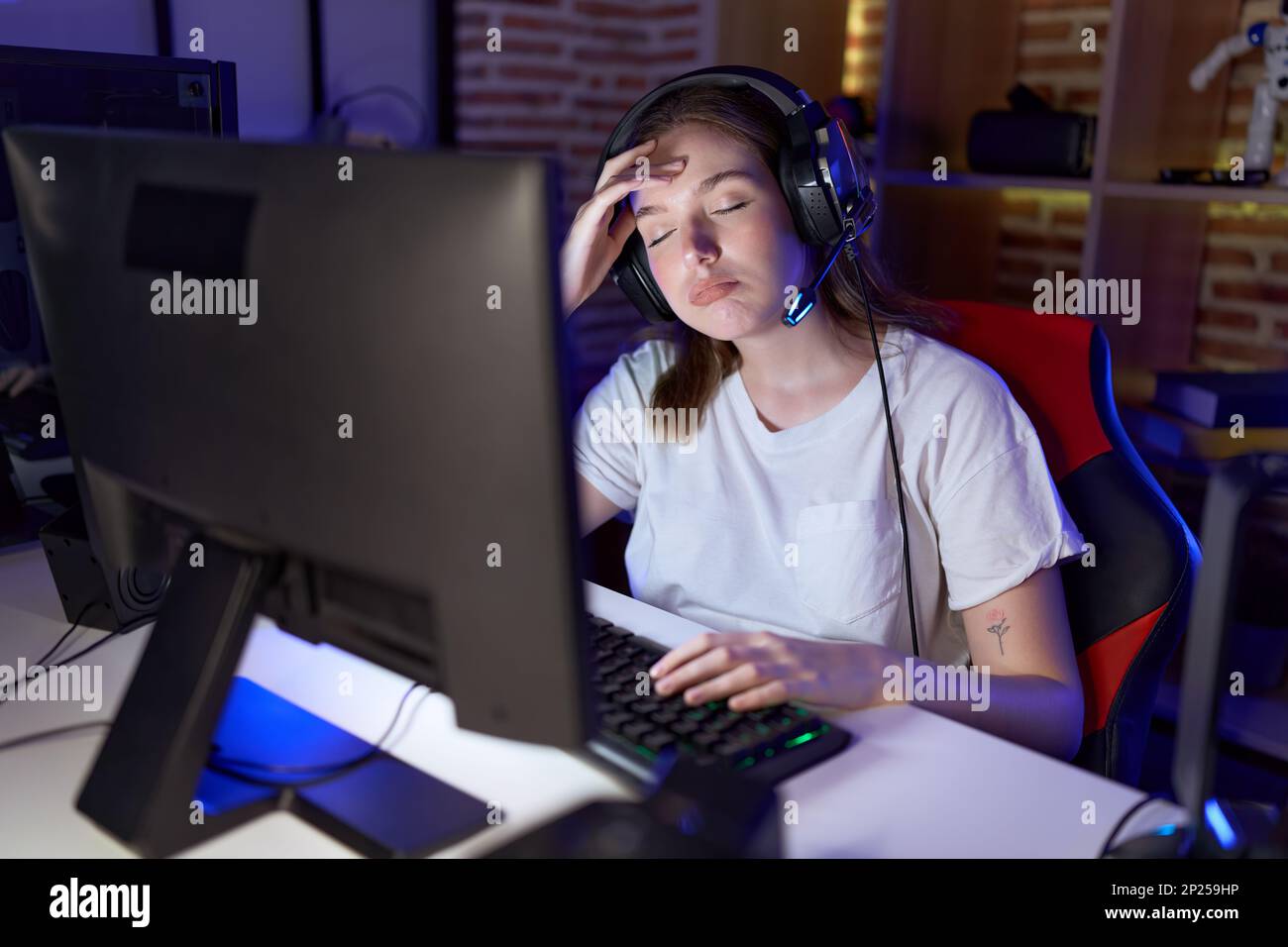 Young caucasian woman streamer stressed using computer at gaming room ...