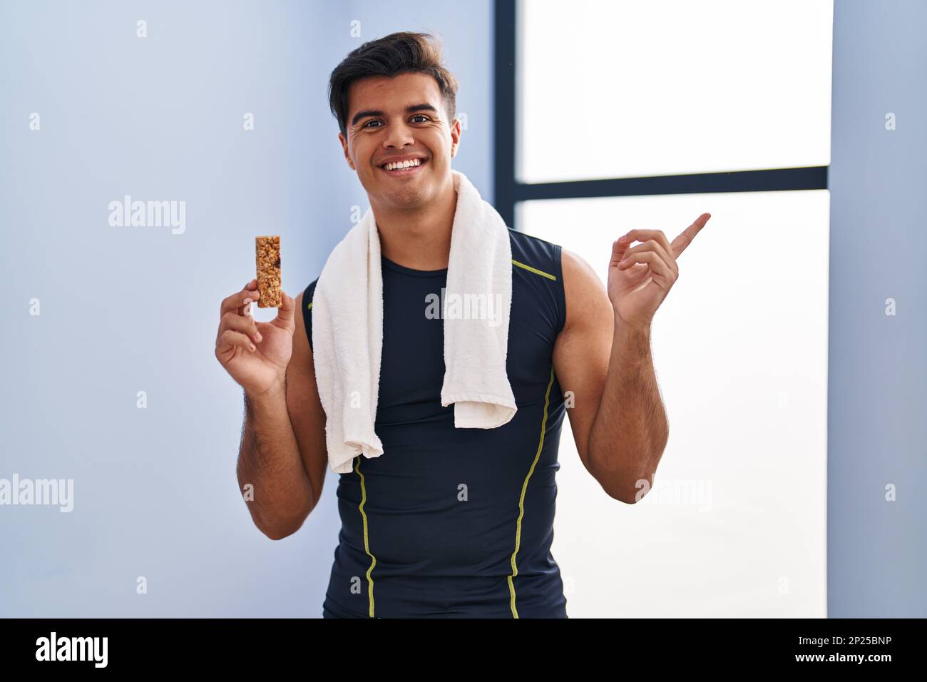 Hispanic man eating protein bar as healthy energy snack smiling happy ...