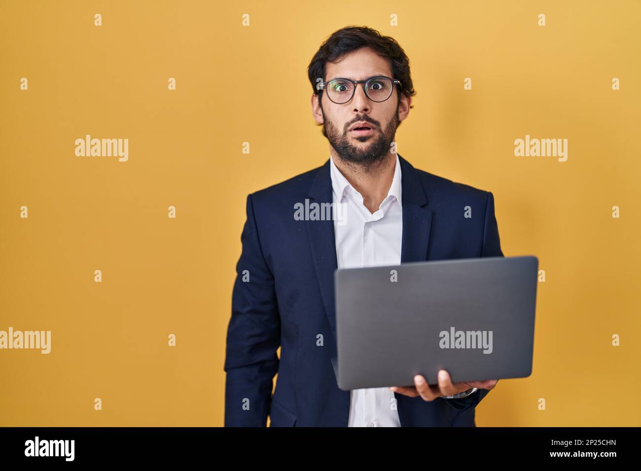 Handsome latin man working using computer laptop in shock face, looking ...