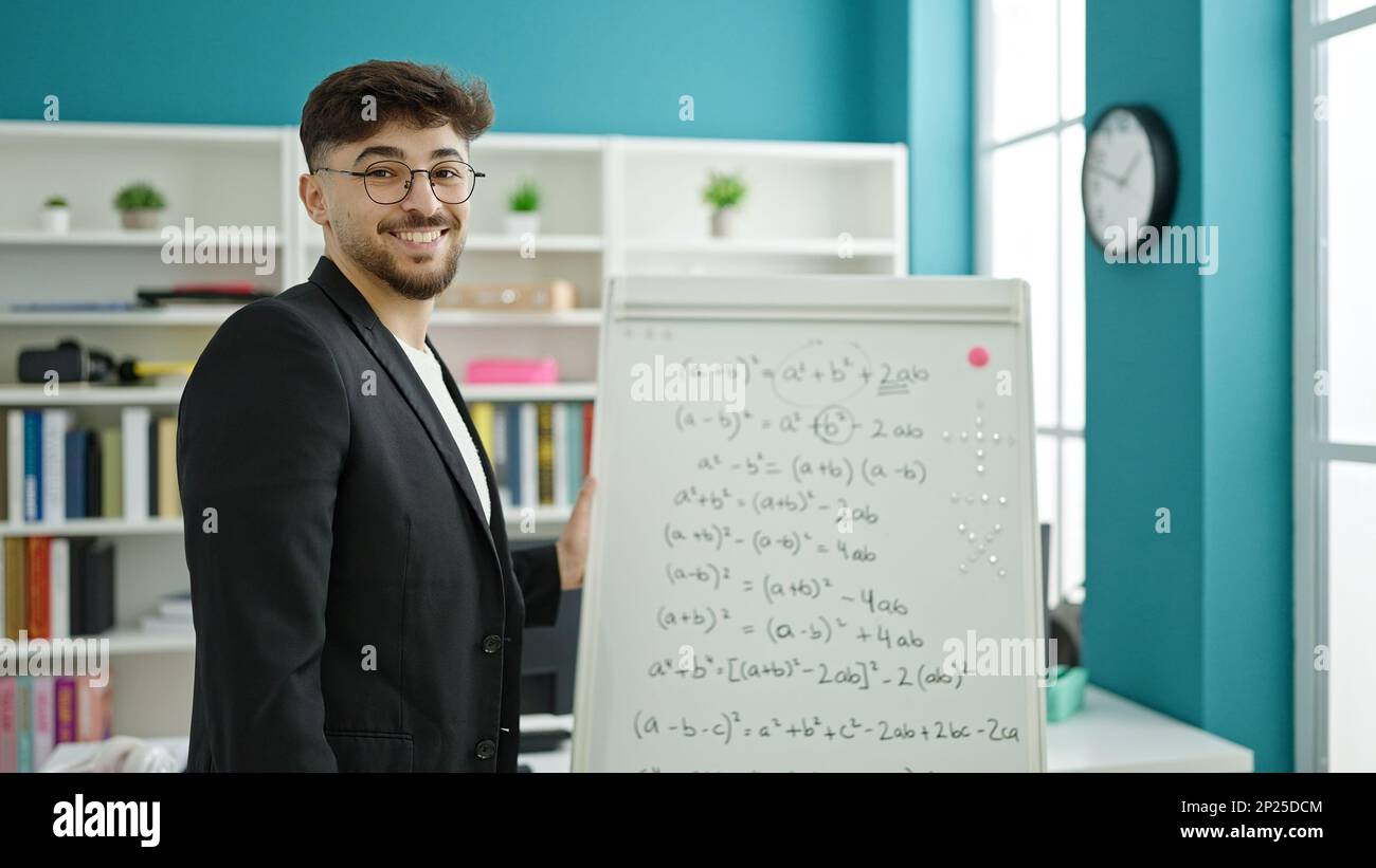 Young arab man teacher teaching maths lesson at university classroom ...