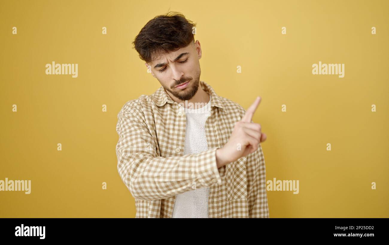 Young arab man doing no gesture with finger over isolated yellow ... Young arab man doing no gesture with finger over isolated yellow ...