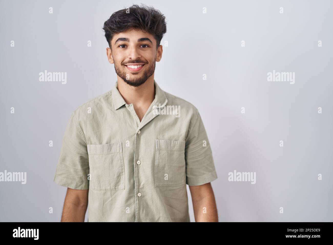 Arab man with beard standing over white background with a happy and ...