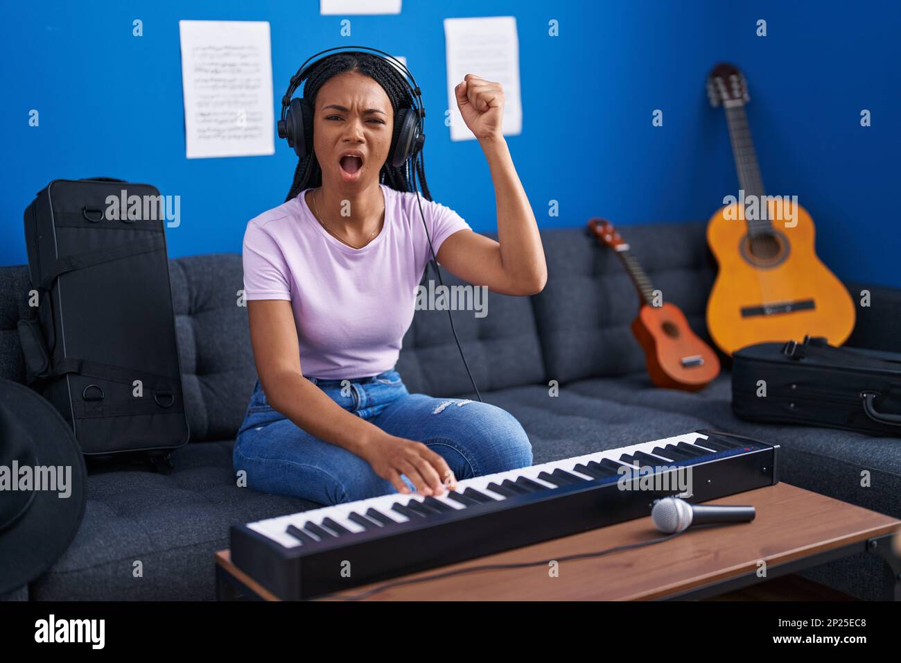 African american woman with braids playing piano keyboard at music ...