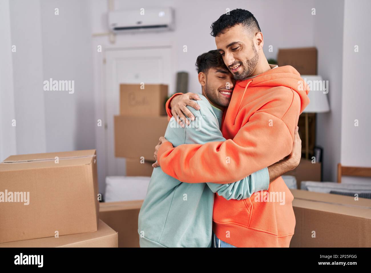 Two man couple hugging each other standing at new home Stock Photo - Alamy