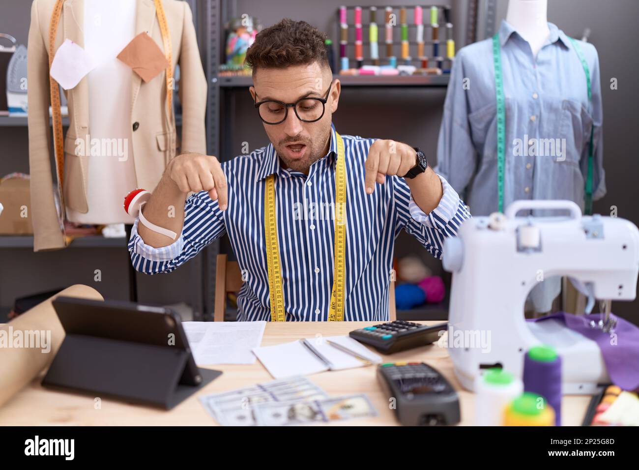 Hispanic man with beard dressmaker designer working at atelier pointing ...