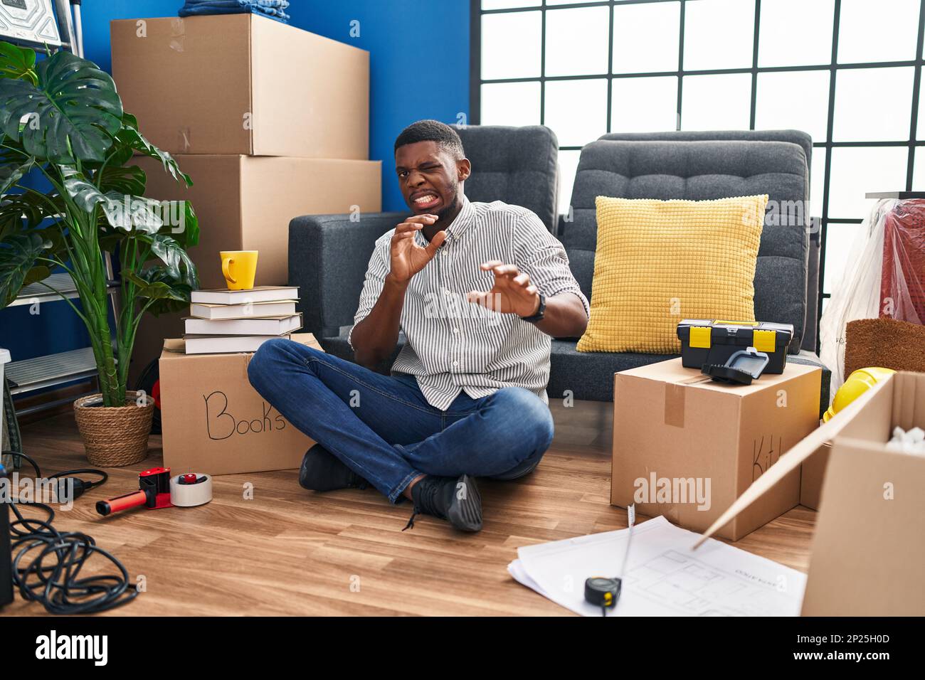 African american man sitting on the floor at new home disgusted ...