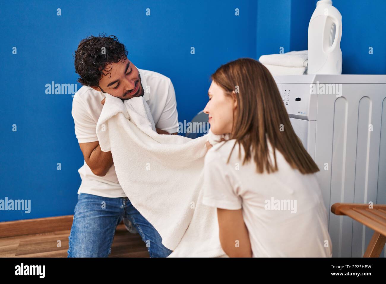 Man and woman couple smiling confident smelling towel at laundry room Stock Photo - Alamy