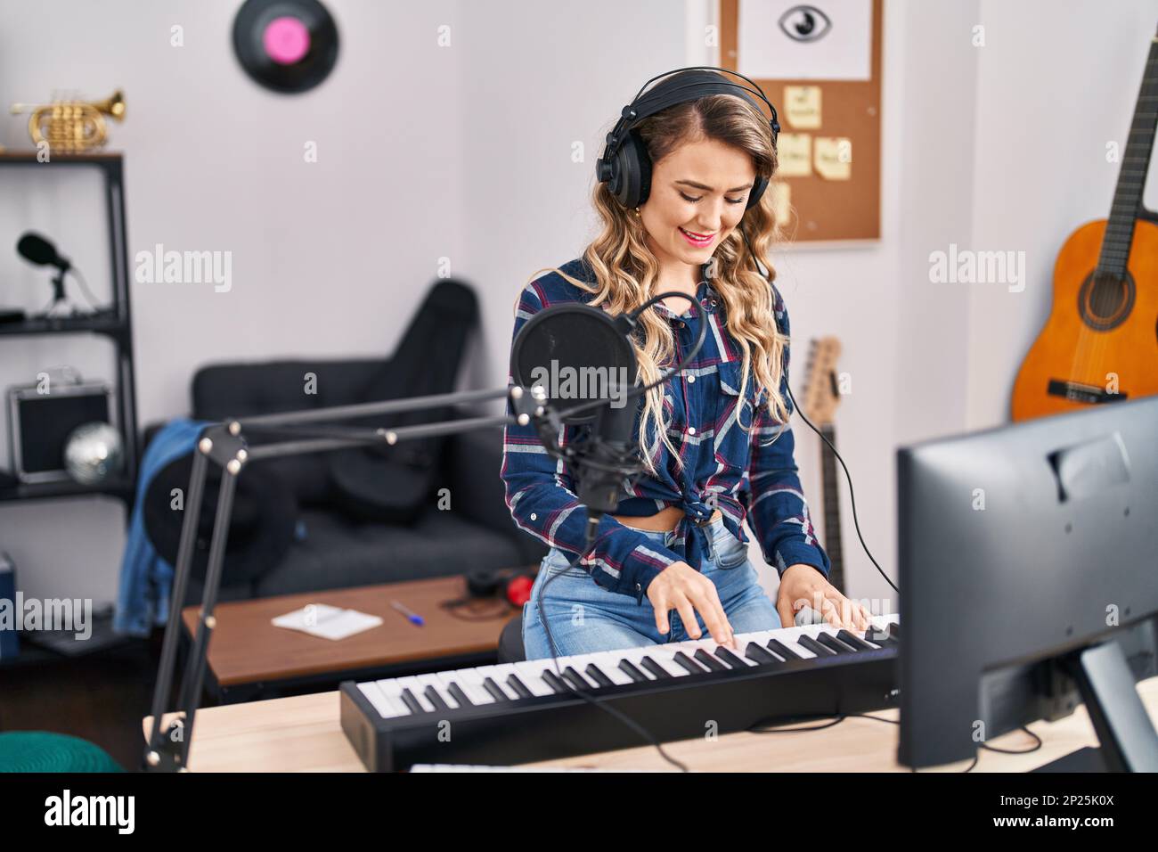 Young woman musician playing piano keyboard at music studio Stock Photo ...
