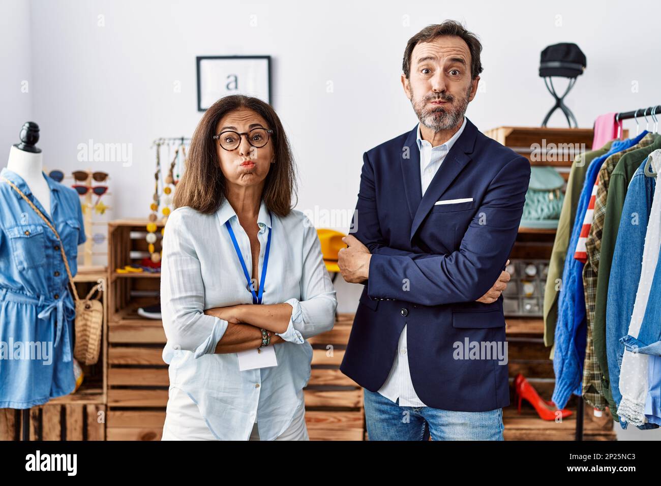 Two hispanic people working as manager at retail boutique puffing ...