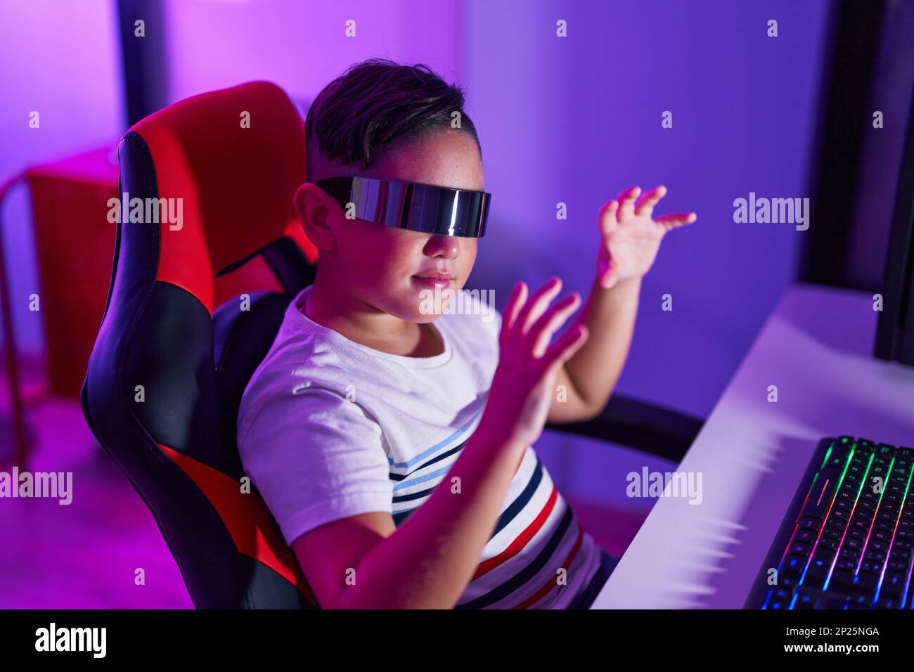 Adorable hispanic boy streamer playing video game using virtual reality ...