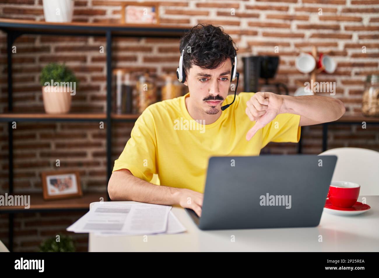 Hispanic man wearing call center agent headset working from home with ...