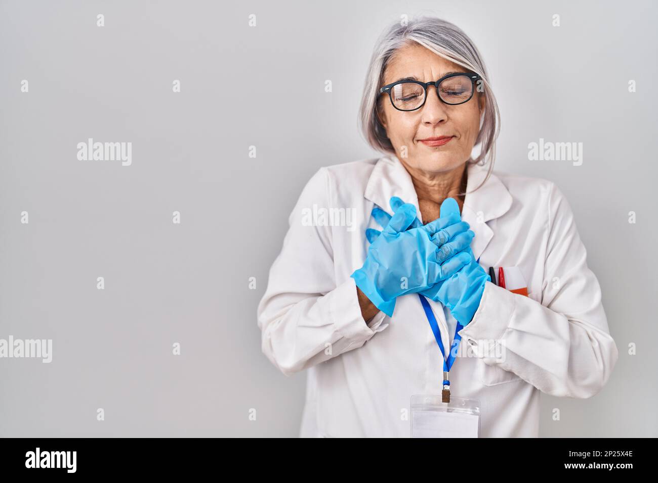 Middle age woman with grey hair wearing scientist robe smiling with ...