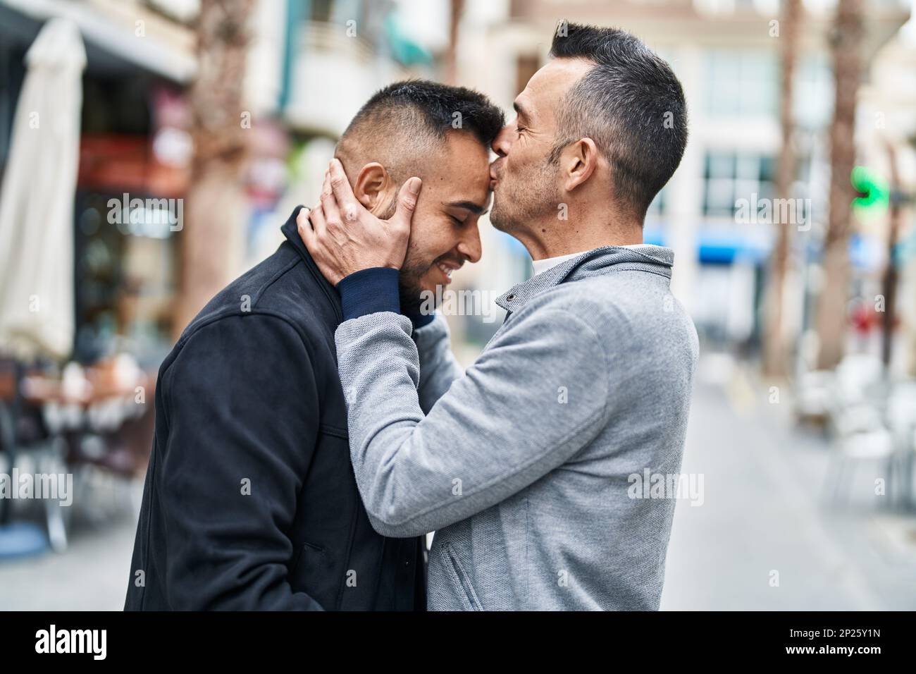 Two Men Couple Hugging Each Other Kissing At Coffee Shop Terrace Stock