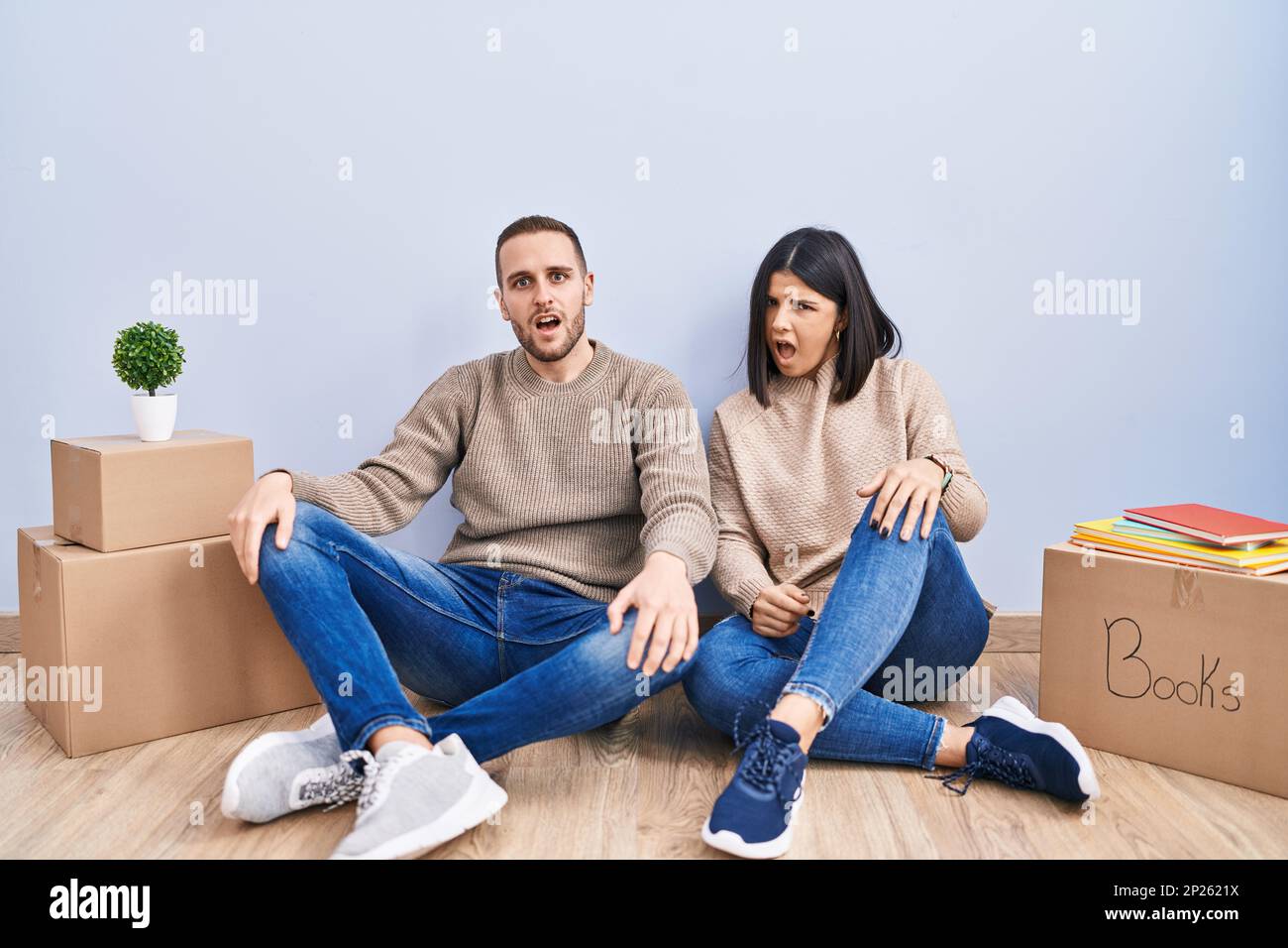 Young Couple Moving To A New Home In Shock Face Looking Skeptical And