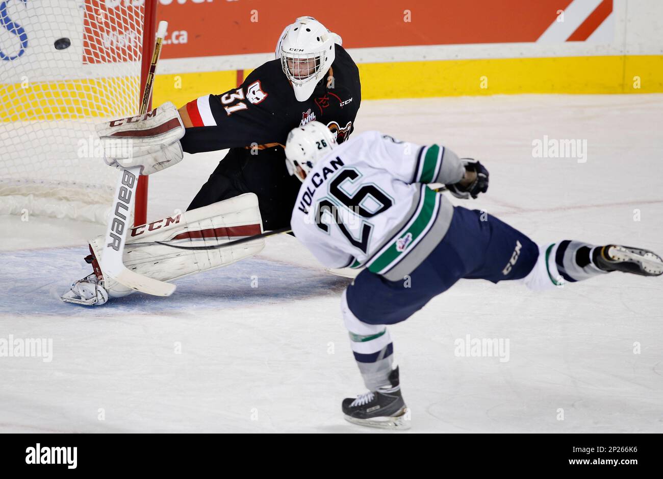 Seattle Thunderbirds' Nolan Volcan, right, scores against Calgary ...