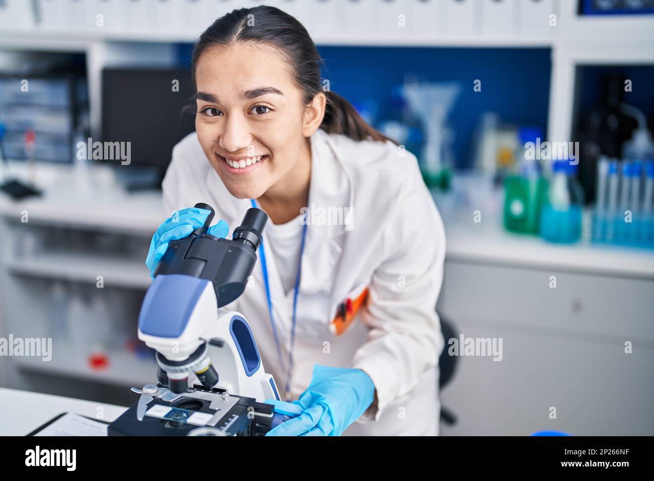 Young hispanic woman scientist using microscope at laboratory Stock Photo - Alamy
