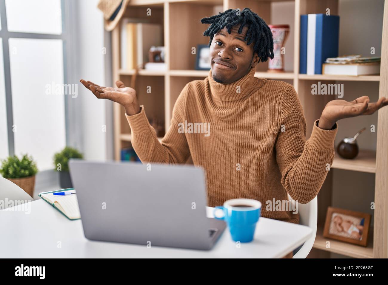 Young african man with dreadlocks working using computer laptop ...