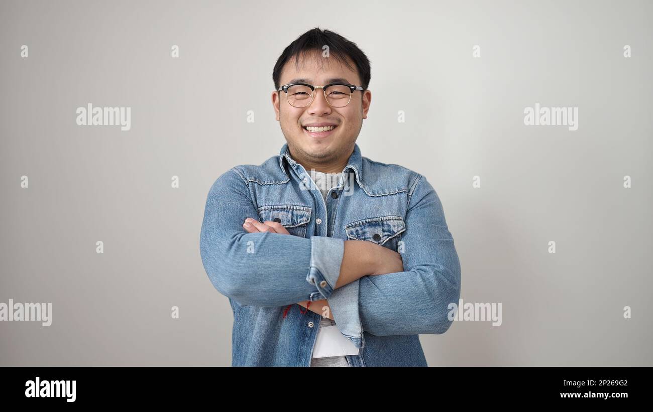 Young chinese man smiling confident standing with arms crossed gesture ...