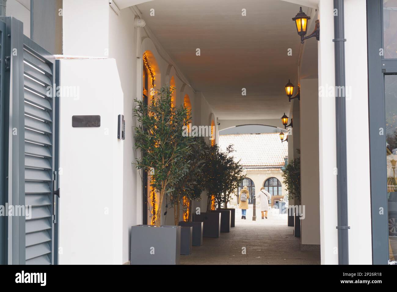 a passage way by a building with plants Stock Photo - Alamy