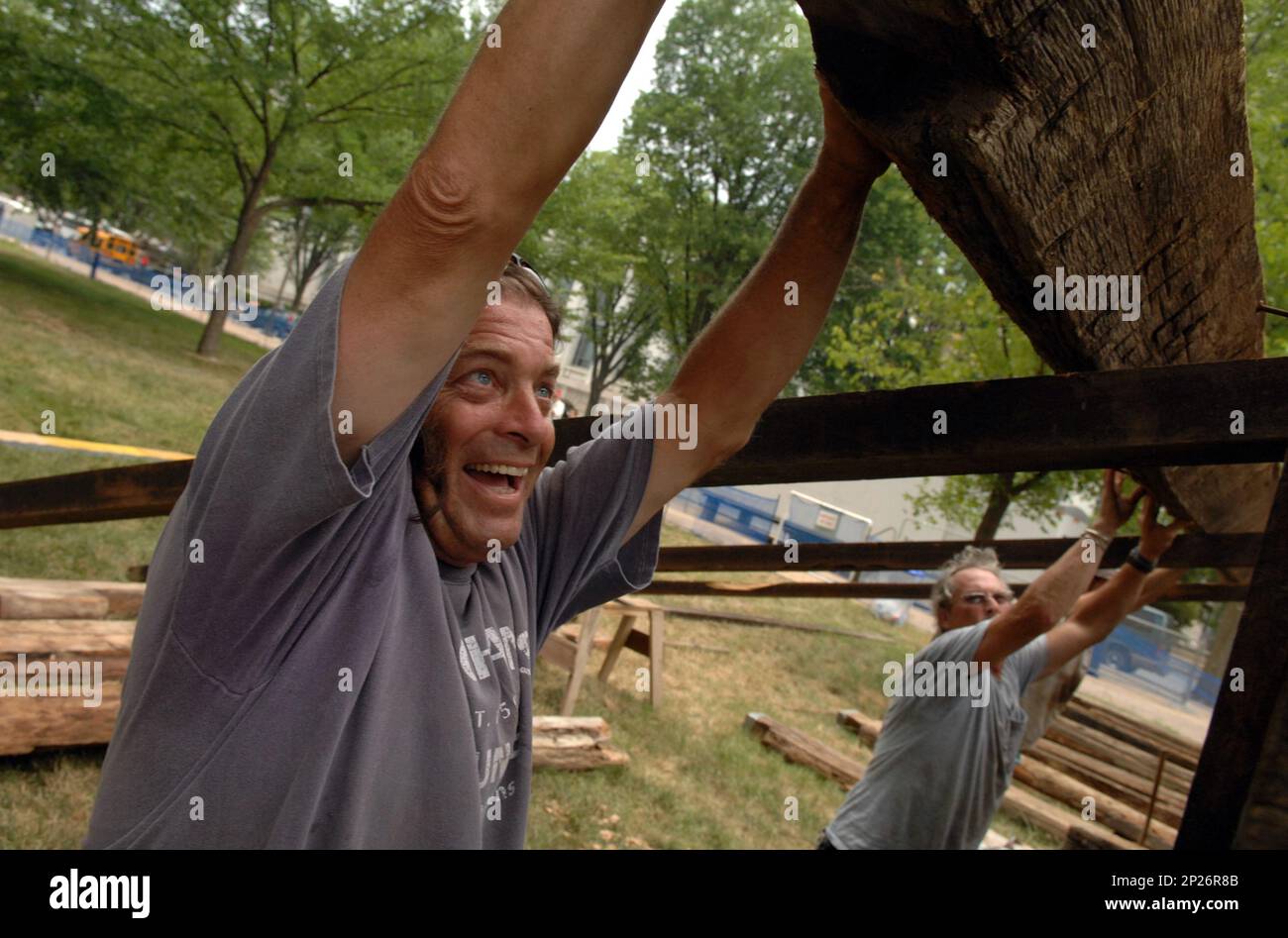 Glenn James lifts an oak log onto the Appalachian log cabin exhibit at ...