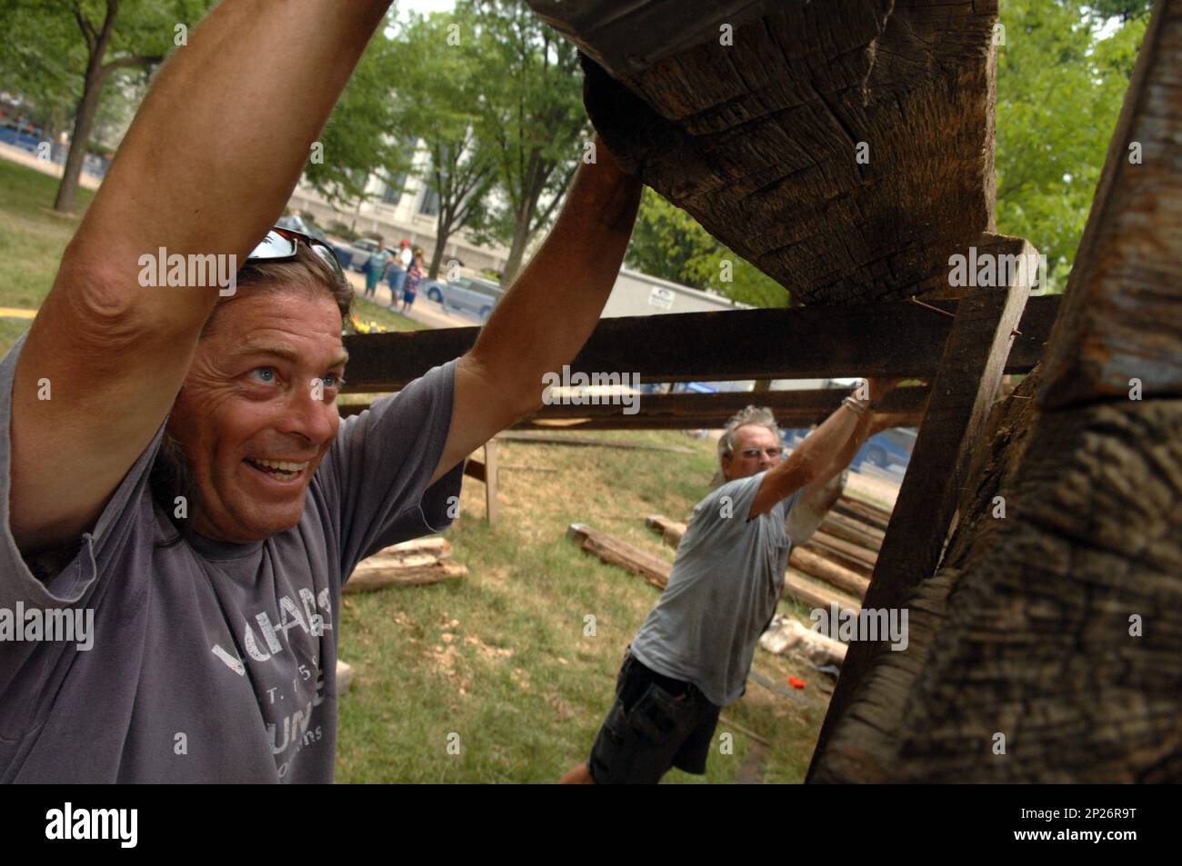 Glenn James lifts an oak log onto the Appalachian log cabin exhibit at ...