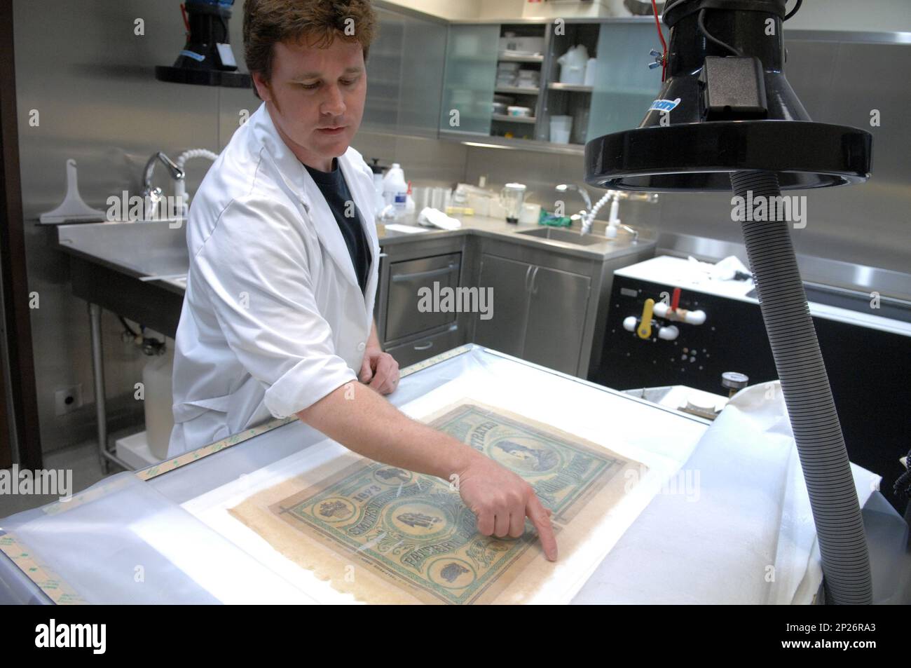 Barry Spence practices paper splitting, a conservation treatment, on an ...
