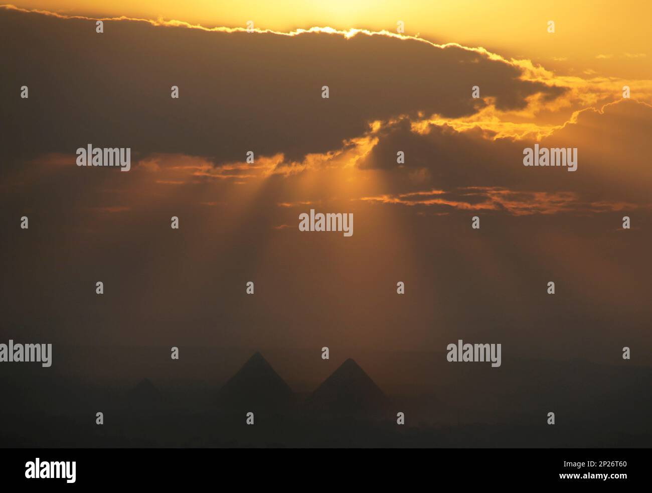 The sun hides behind clouds over the historical site of the Giza ...