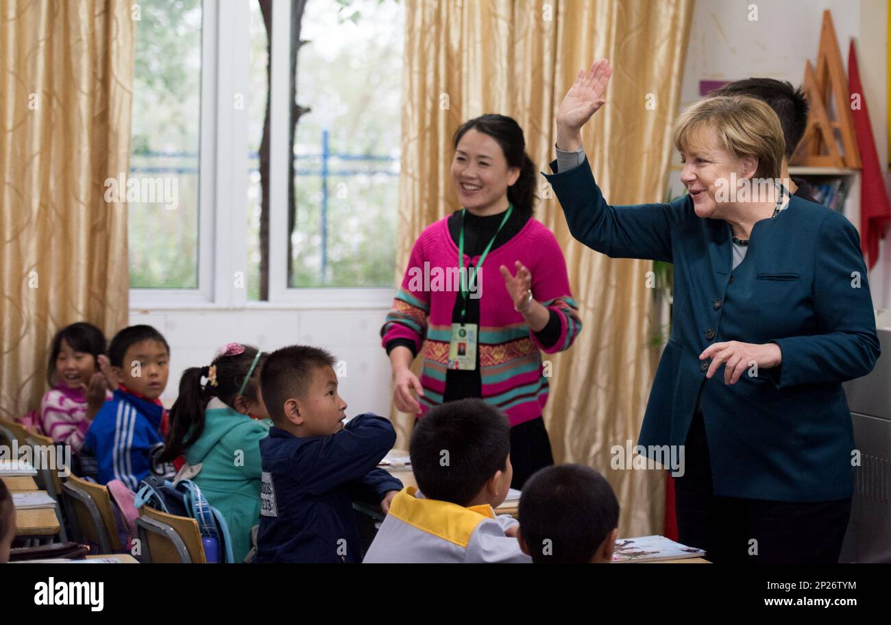 German Chancellor Angela Merkel, right, talks to children of the ...