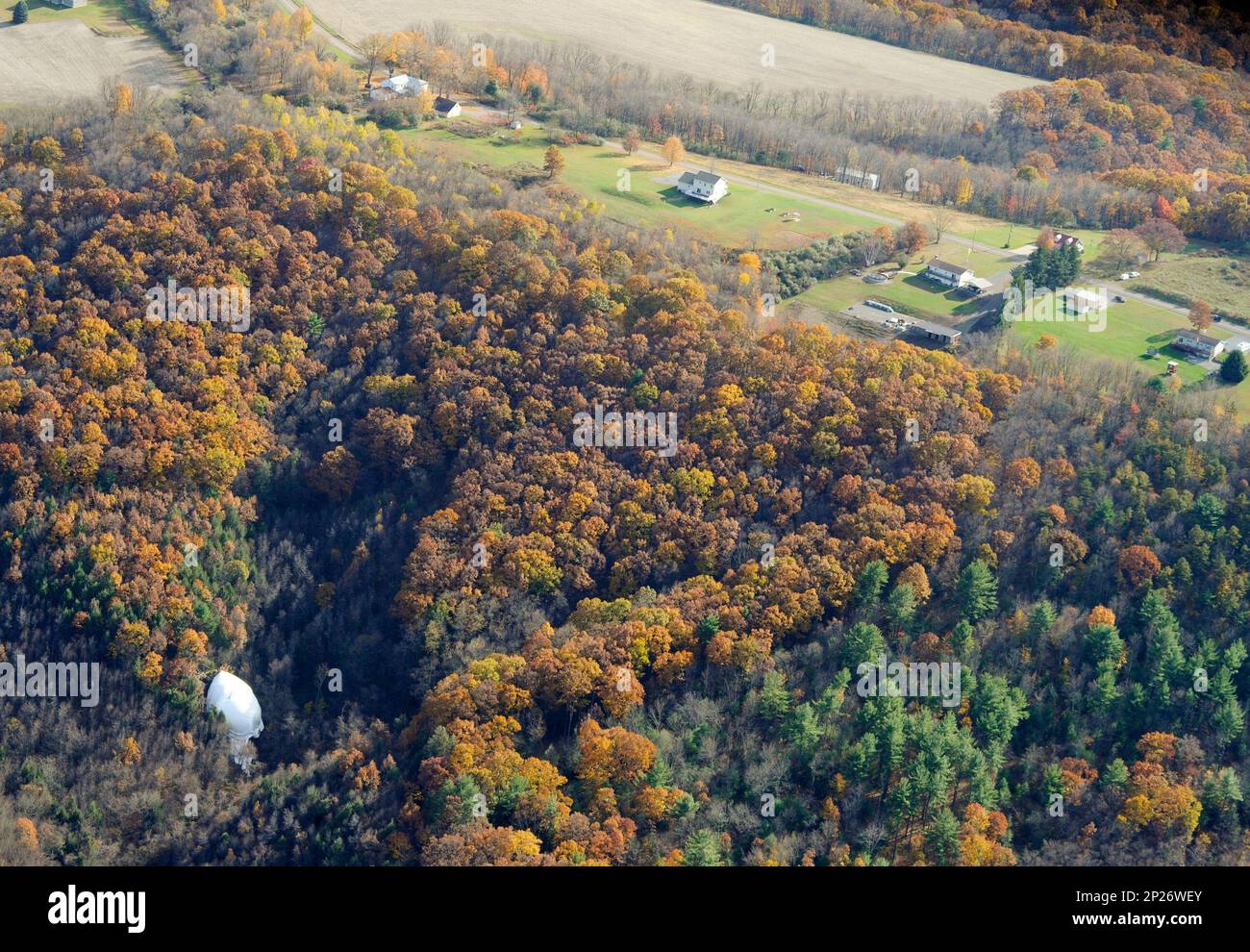 A section of an unmanned Army surveillance blimp sits in a wooded area ...