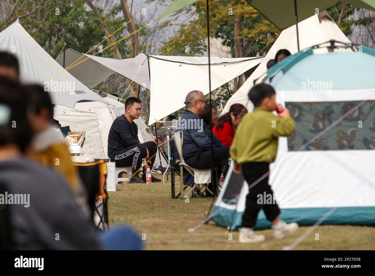 People rest under their tents in a riverside park in southwest China's ...