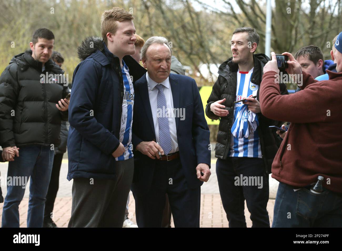 Huddersfield Town manager Neil Warnock (centre) meeting a fan outside ...